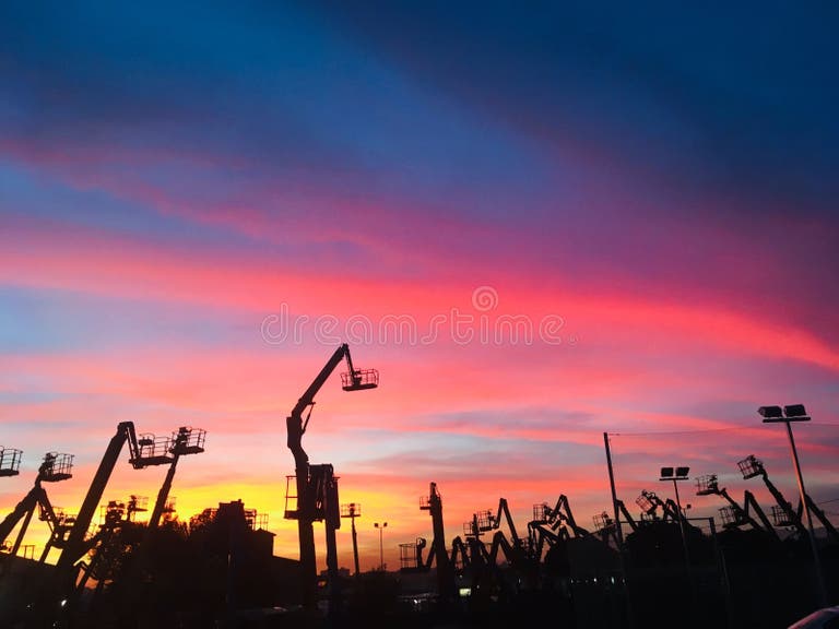 Construction Site at Sunset, Illuminated by a Vibrant Pink and Blue Sky ...