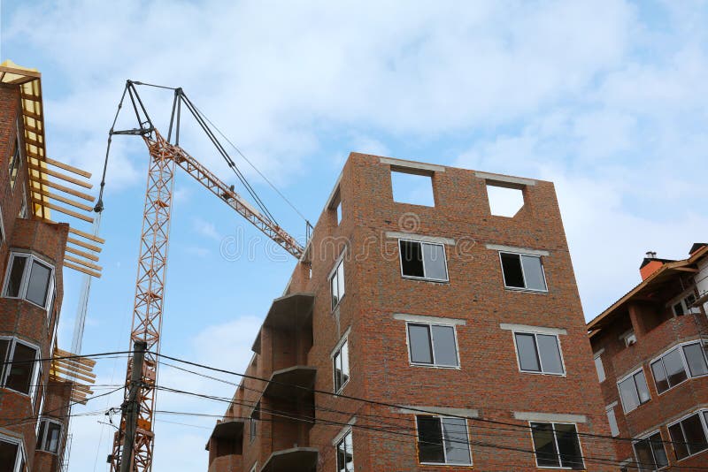 Construction Site with Tower Crane Near Unfinished Buildings, Low Angle ...