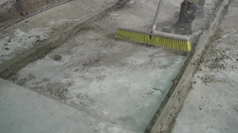 Construction Site, a Worker Cleans the Floor with a Brush. Broom at a ...