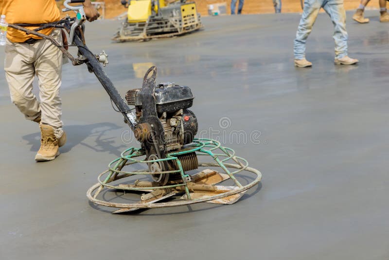 In a Construction Site, a Worker Polishes and Levels a Cement Screed ...