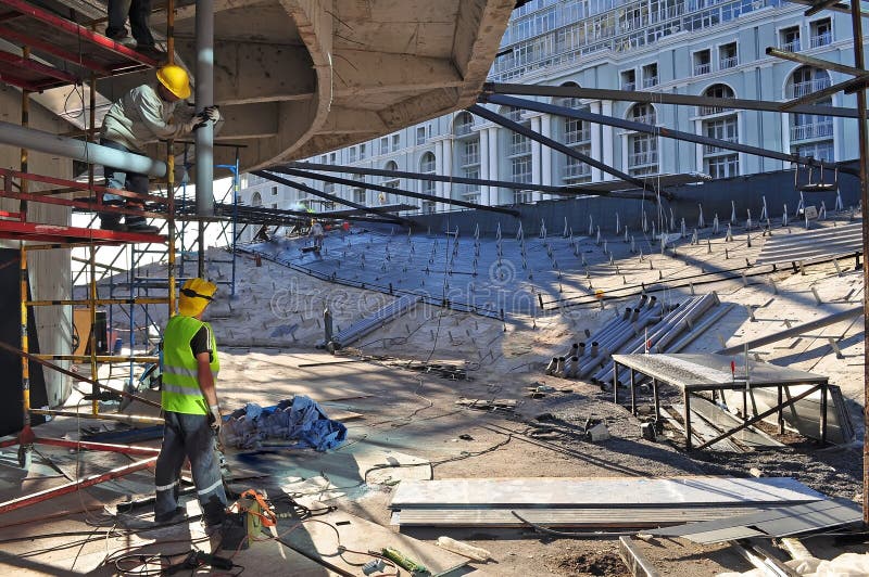 Construction Site with Workers in Bright Vests Busy with Construction ...