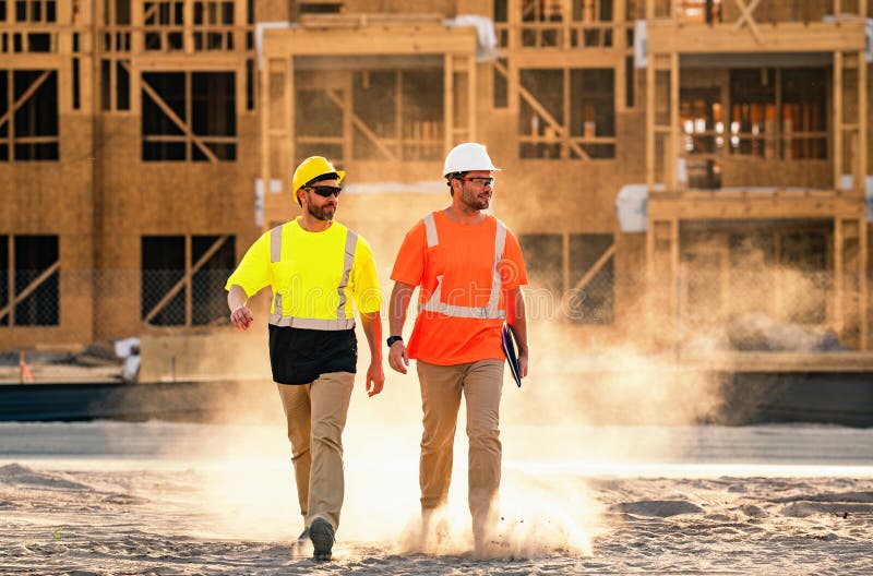 Construction Site Workers in a Helmet Work Hard. Two Workers in a Hard ...