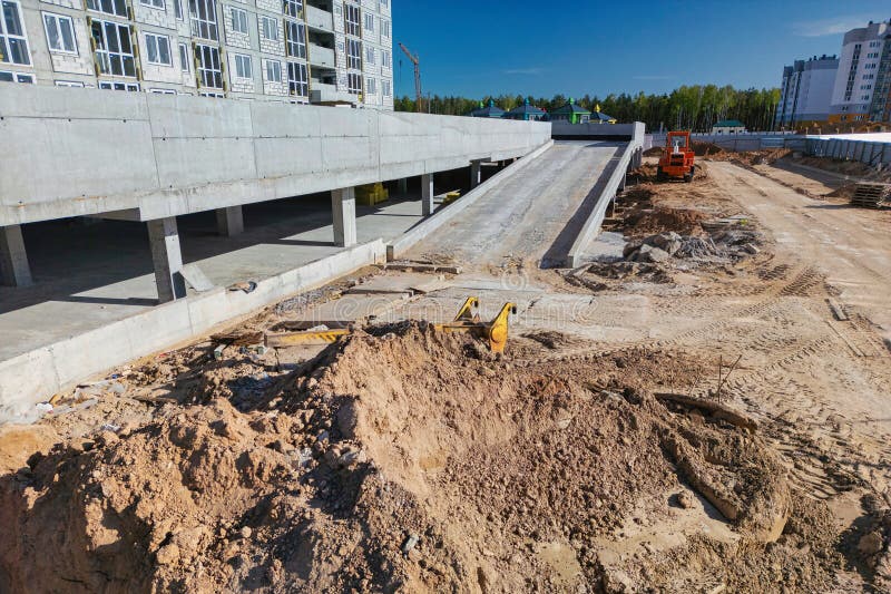 A Construction Site with Workers and Machinery in Front of a Massive ...