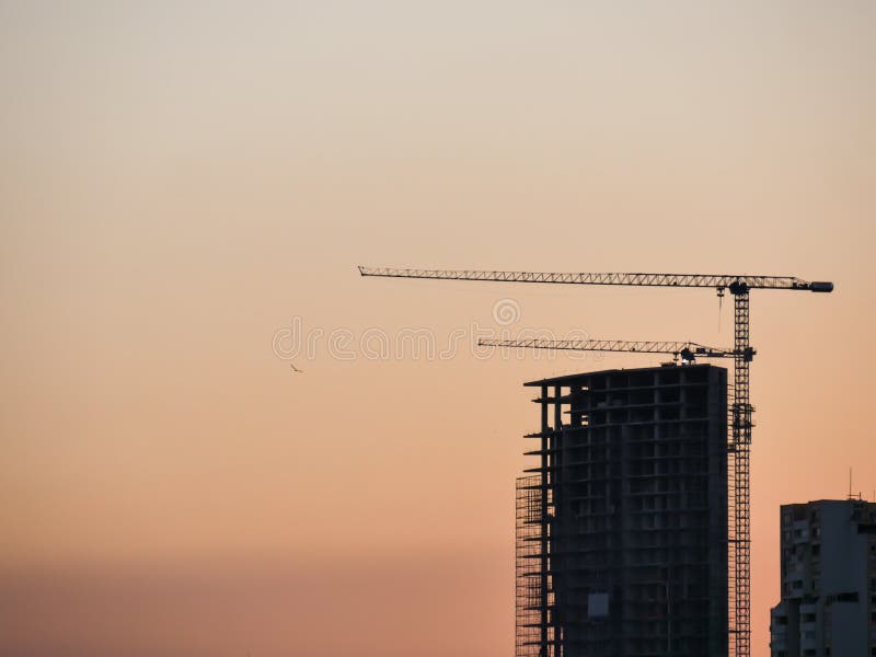 Construction and Sky-scraper Building and Crane Against Colorful Sky ...
