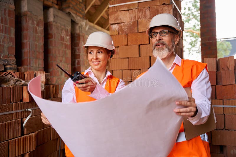 Construction Specialists Using Blueprints during Site Inspection Stock ...