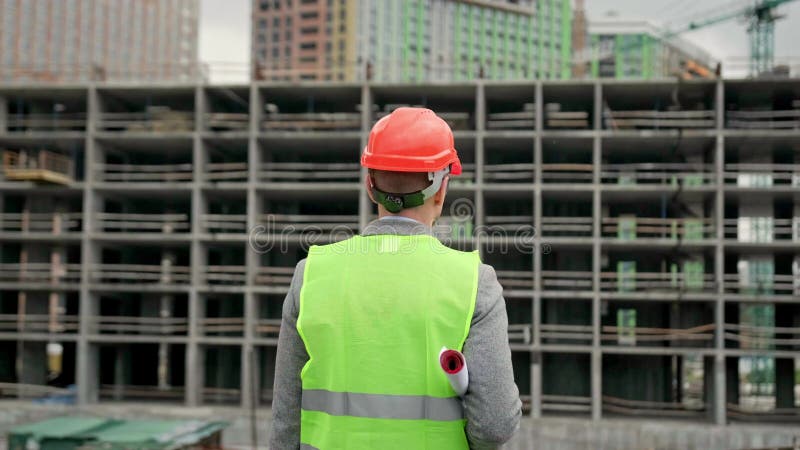 Construction Superintendent with Drawings Approaching New Building ...