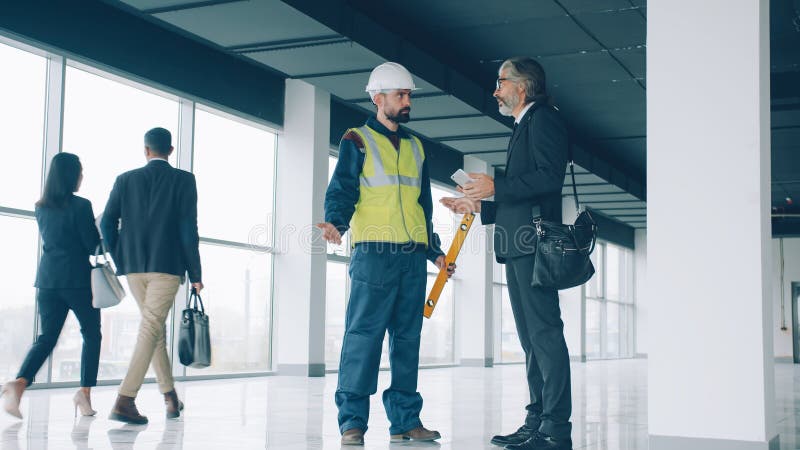 Construction Supervisor Talking on Mobile Phone Then Discussing Project ...