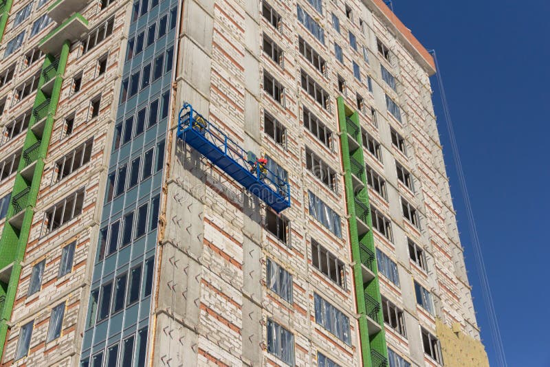 Construction Cradle with Workers on the Facade of the Building ...
