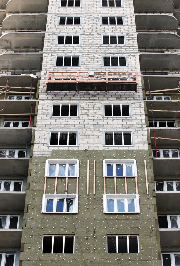 Construction Suspended Yellow Cradle with Workers on a Newly Built High ...