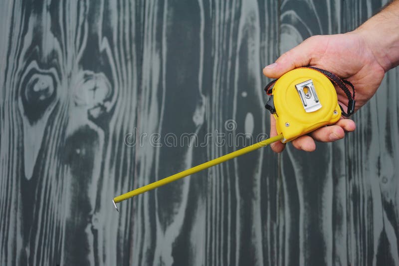 Construction Tape in Hand on Gray Wooden Texture Background Stock Photo ...