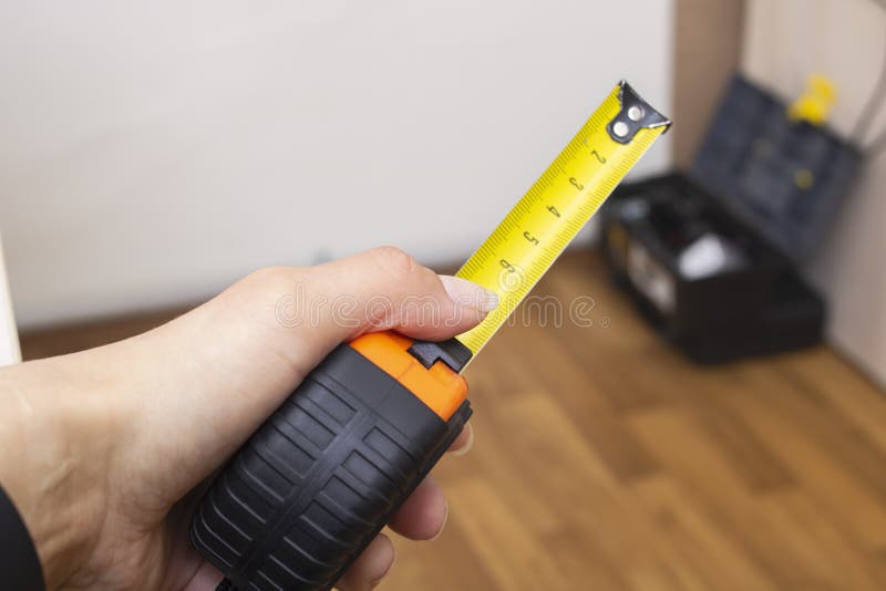 Construction Tape Measure in Hand on Room Background Stock Image ...