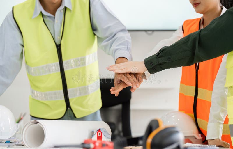 Construction Team Emphasizing Teamwork with Hands Together in a Project ...