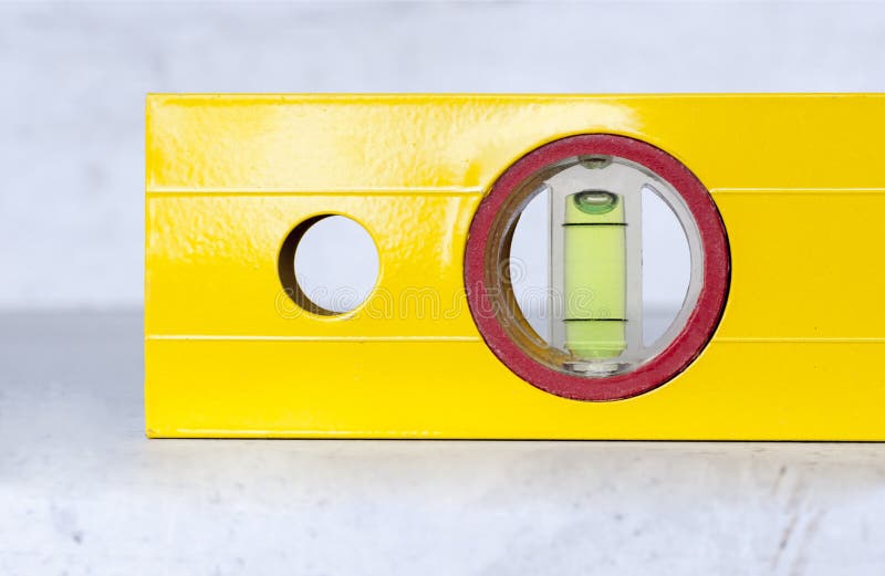 Construction Tools a Bright Yellow Level on a Light Concrete Background ...