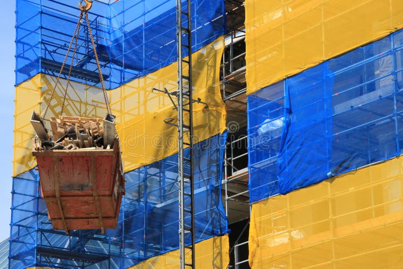 The Construction Waste Container is Hanging in the Tower Crane Above ...