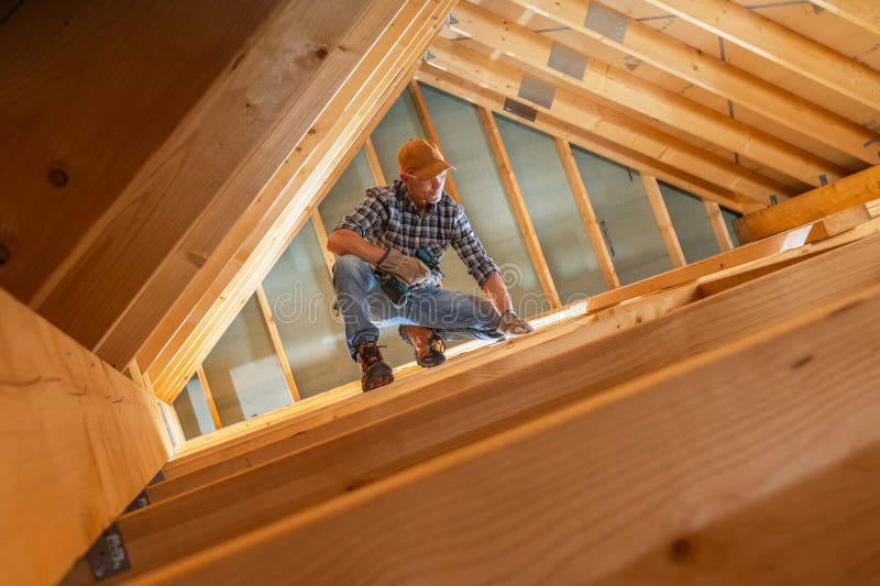 Construction Work in an Attic with Beams and a Skilled Worker Using ...