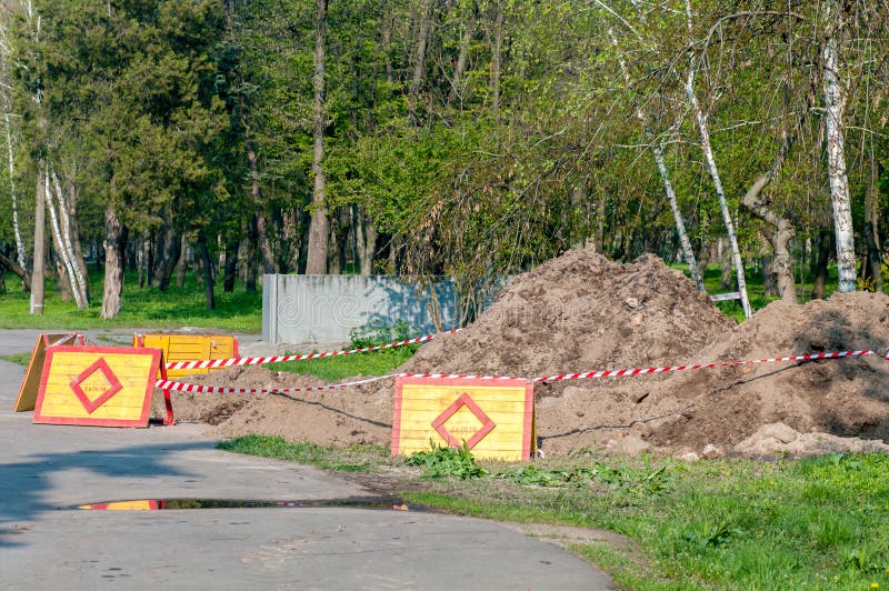 Construction Work, a Dug Hole with a Warning Sign in the Park Stock ...
