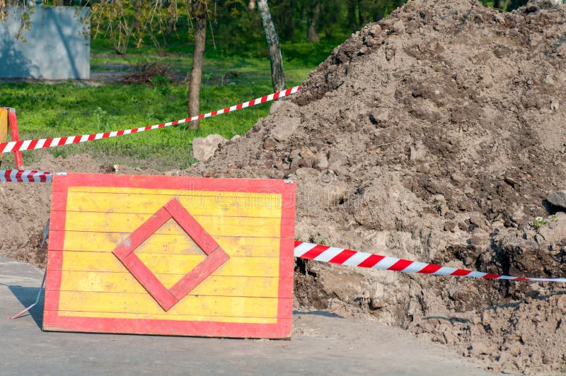 Construction Work, a Dug Hole with a Warning Sign in the Park Stock ...