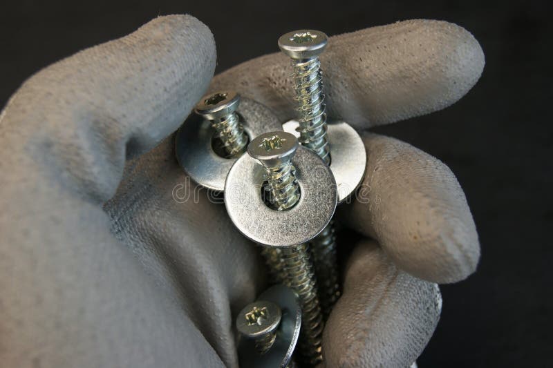 The Builder Holds Large Screws. Construction Work Process. Stock Image ...