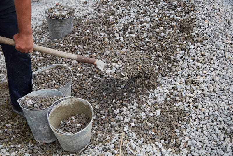 Construction Work, Worker Fill Gravel with a Shovel in Buckets Stock ...