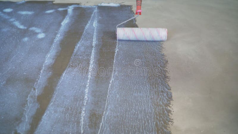 Construction Worker Applying Epoxy Resin on Concrete Floor Using Roller ...