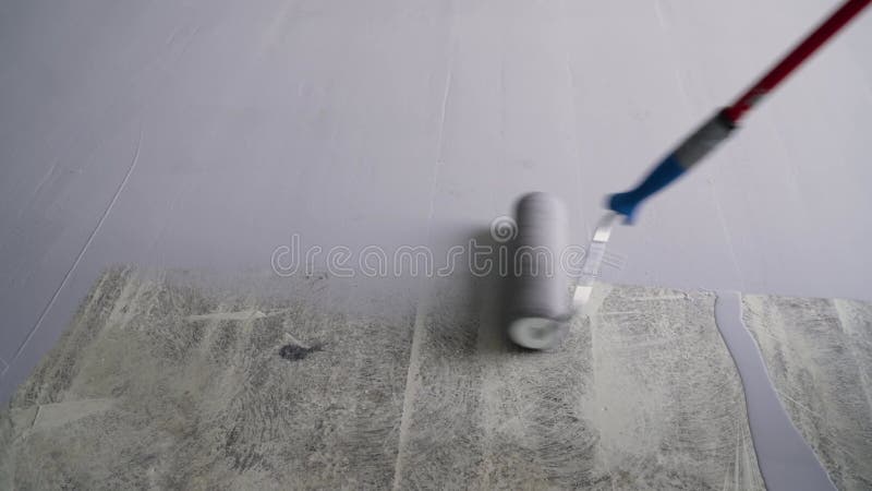 Construction Worker Applying Epoxy Coating on Concrete Floor Using a ...