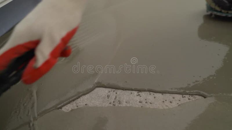Construction Worker Applying Grey Epoxy Resin in an Industrial Hall ...