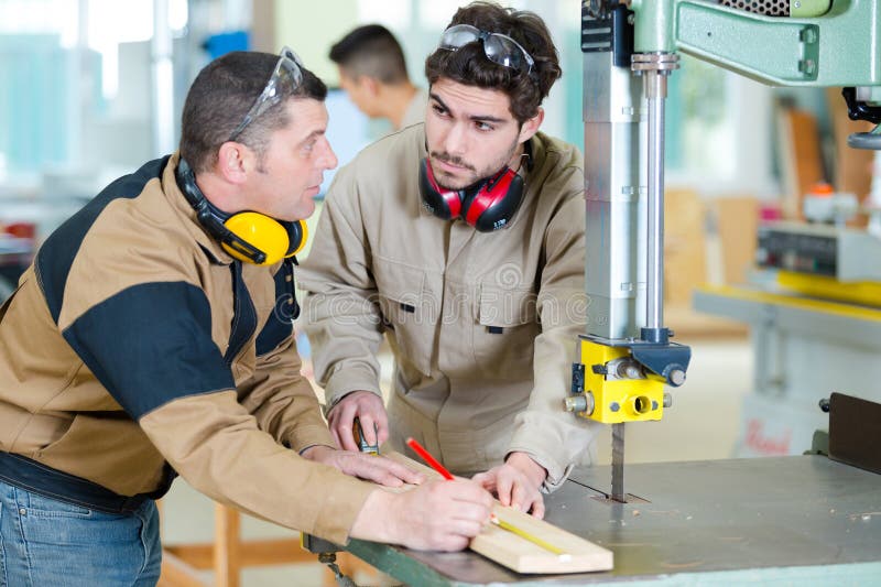 Construction Worker and Apprentice in Workshop Stock Image - Image of ...