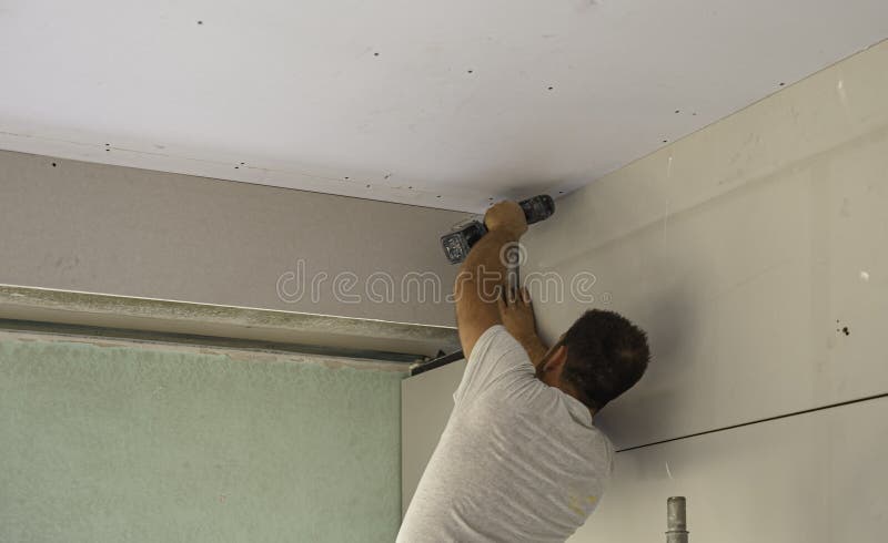 Construction Worker Assemble a Suspended Ceiling with Drywall Stock Photo - Image of drill ...
