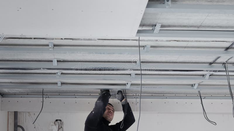 Construction Worker Assemble a Suspended Ceiling with Drywall and ...