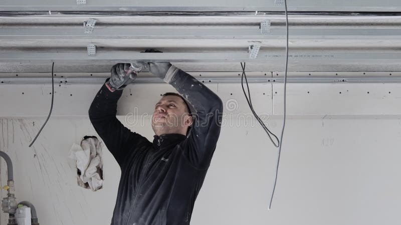Construction Worker Assemble a Suspended Ceiling with Drywall and ...