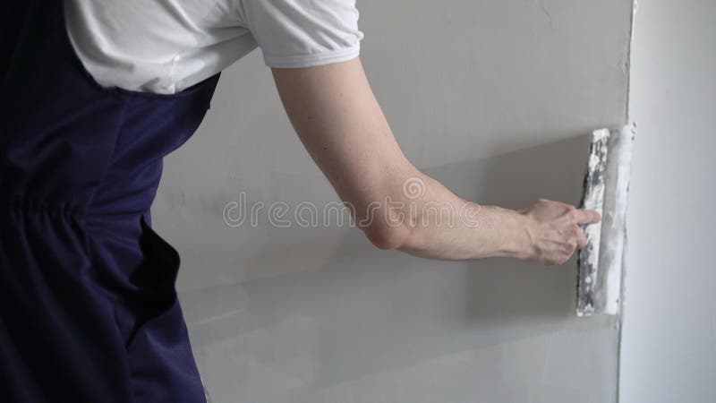 A Construction Worker Builder Makes Repairs Renovation in an Apartment ...