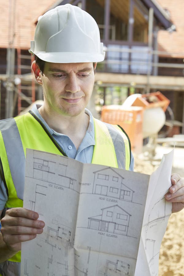 Construction Worker on Building Site Looking at House Plans Stock Photo ...