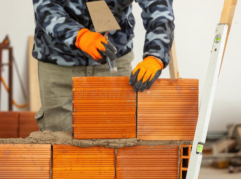 Construction Worker Building a Wall Using Hollow Bricks and Cement ...