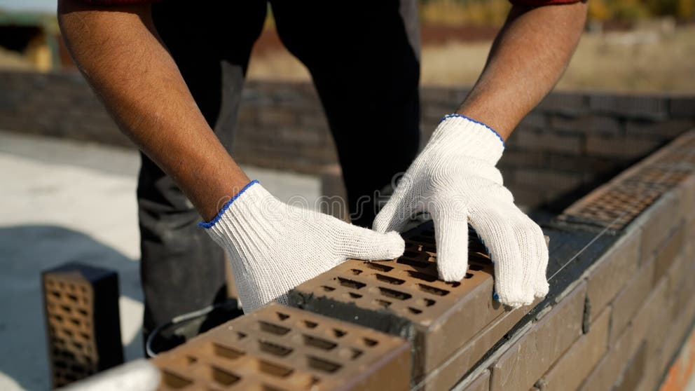Construction Worker Building a Brick Wall with Hammer and Level Stock ...