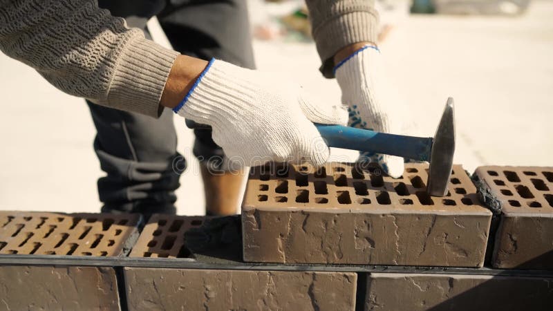 Construction Worker Building a Brick Wall with Hammer and Level Stock ...