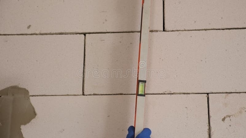 Construction Worker in White Hardhat Checking Level of Wall with the ...