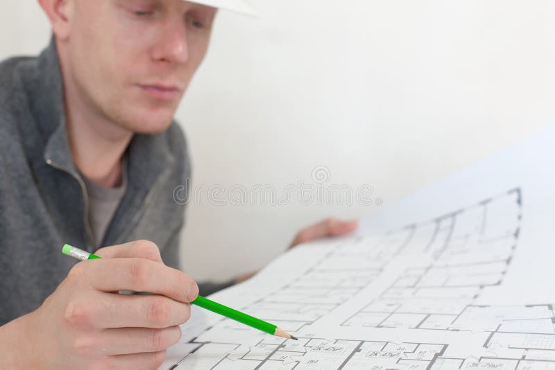 A Construction Worker Checking Documents with Pencil in His Hand Stock ...