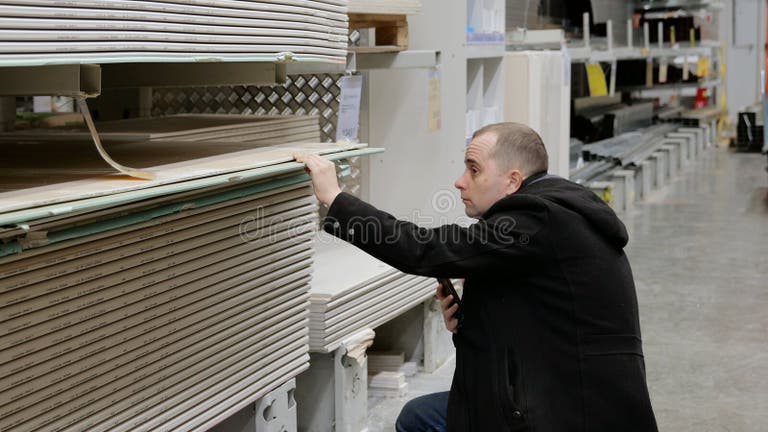 Construction Worker Checking Drywall Sheets at Hardware Store ...