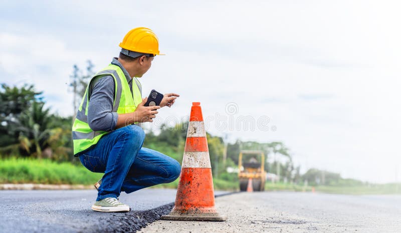 Construction Worker Checking Progress on Mobile Phone Near Traffic Cone ...
