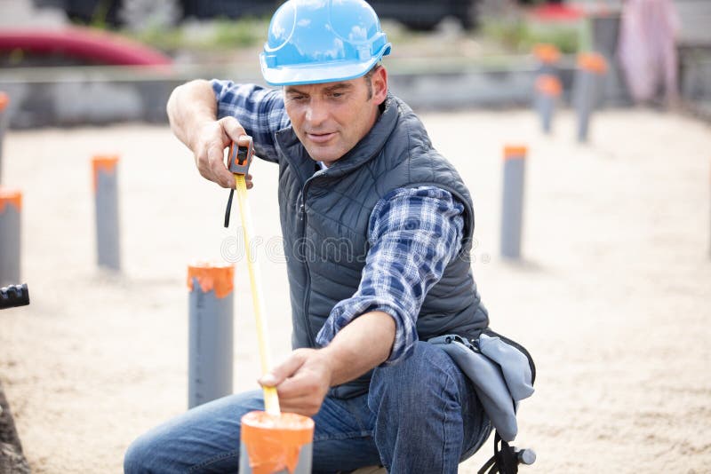 Construction Worker Checking Sanitation Pipes with Measuring Tape Stock ...