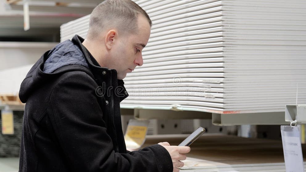 Construction Worker Checking Smartphone, Tracking Drywall Inventory ...