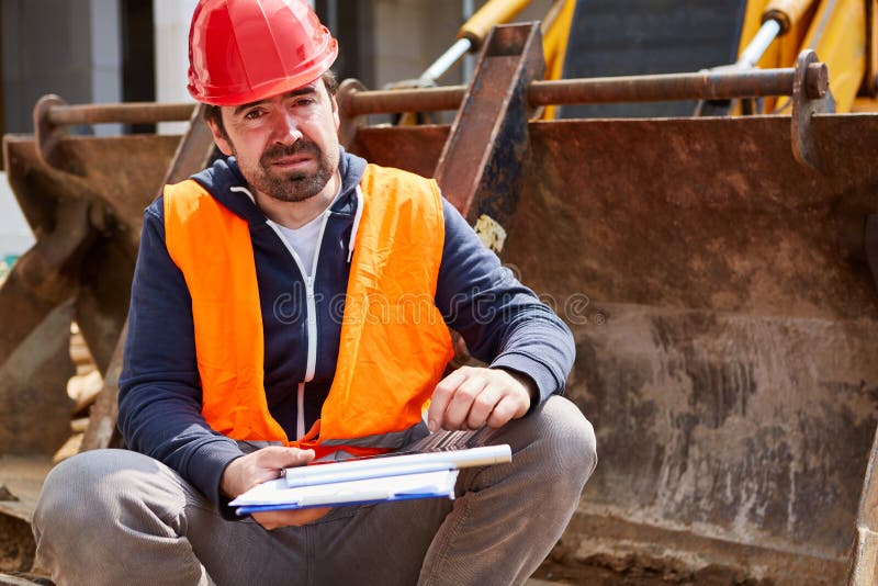 Construction Worker with Checklist Sits on Excavator Bucket Stock Photo ...