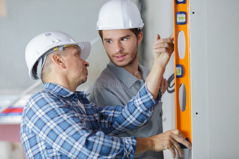 Construction Worker Checks Level on Wall Stock Photo - Image of ...