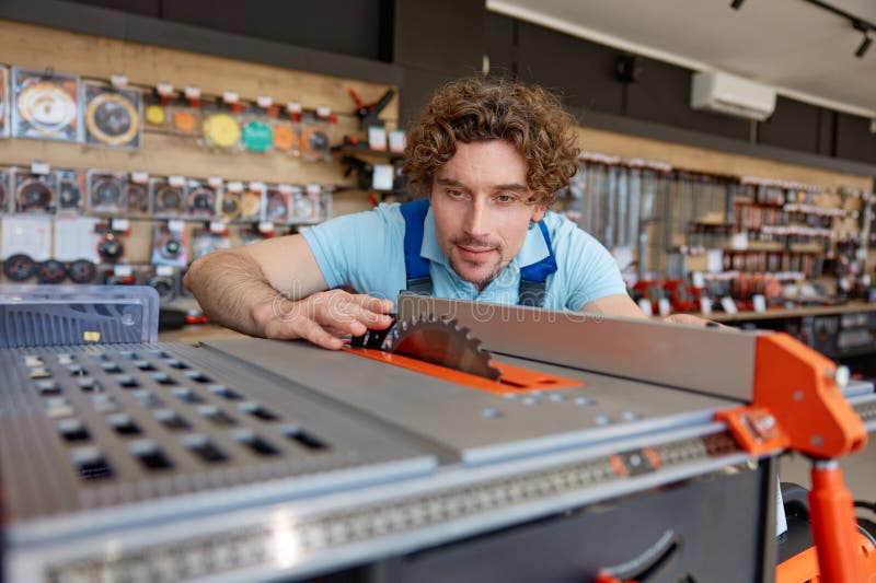 Construction Worker Choosing Table Circular Saw while Shopping at Power ...