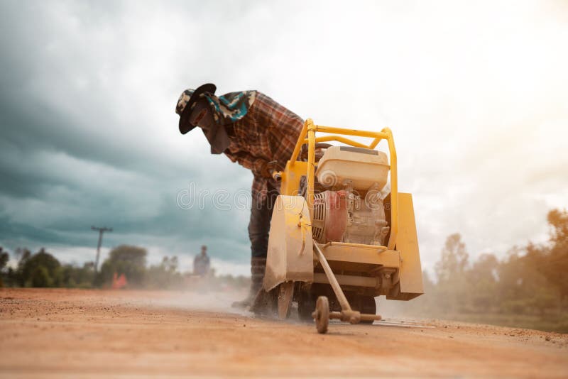 Construction Worker Concrete Cutting in the Road Construction Stock ...