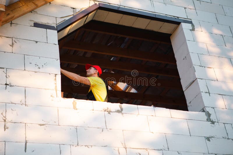 Construction Worker at Construction Site Measures the Length of Window ...