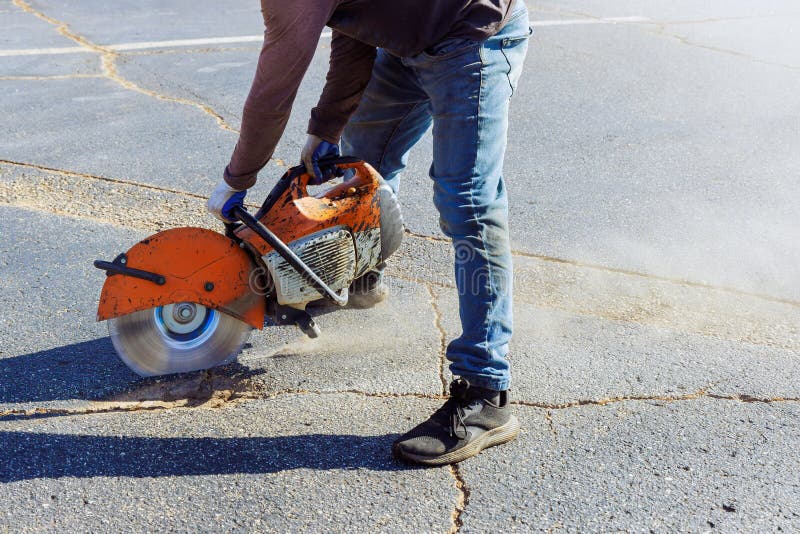 Construction Worker Cuts Damaged Asphalt in Parking with a Diamond ...
