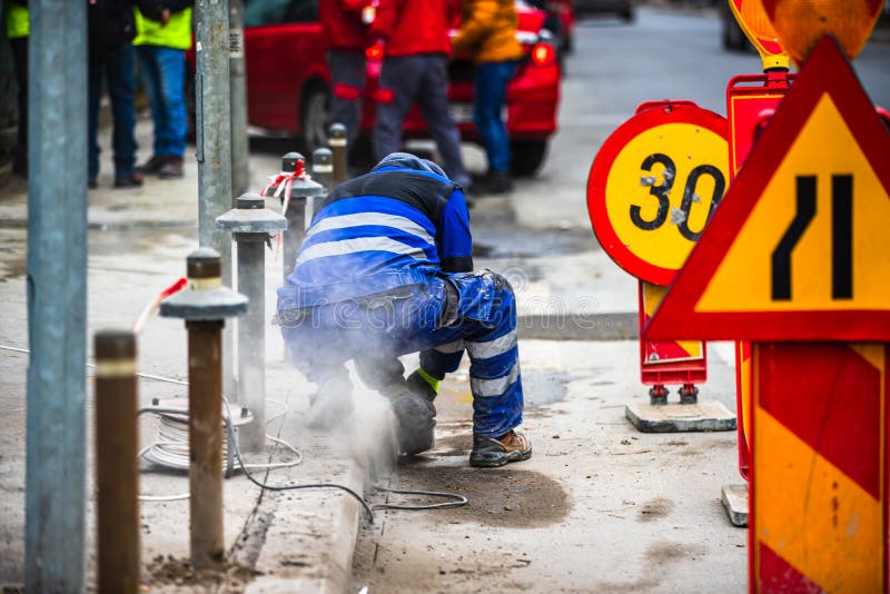 Construction Worker Cutting Asphalt Paving Stabs for Sidewalk Using a ...