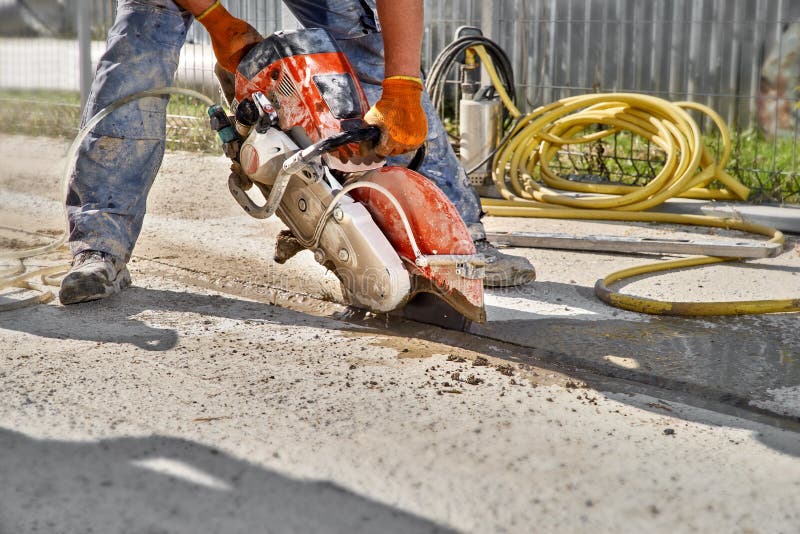 Construction Worker Cutting Concrete Foundation Using a Cut-off Saw ...