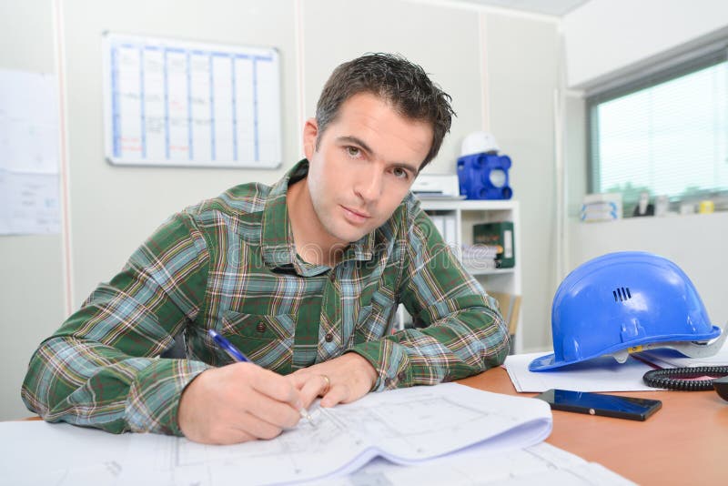 Construction Worker at Desk Stock Image - Image of serious, investigate ...